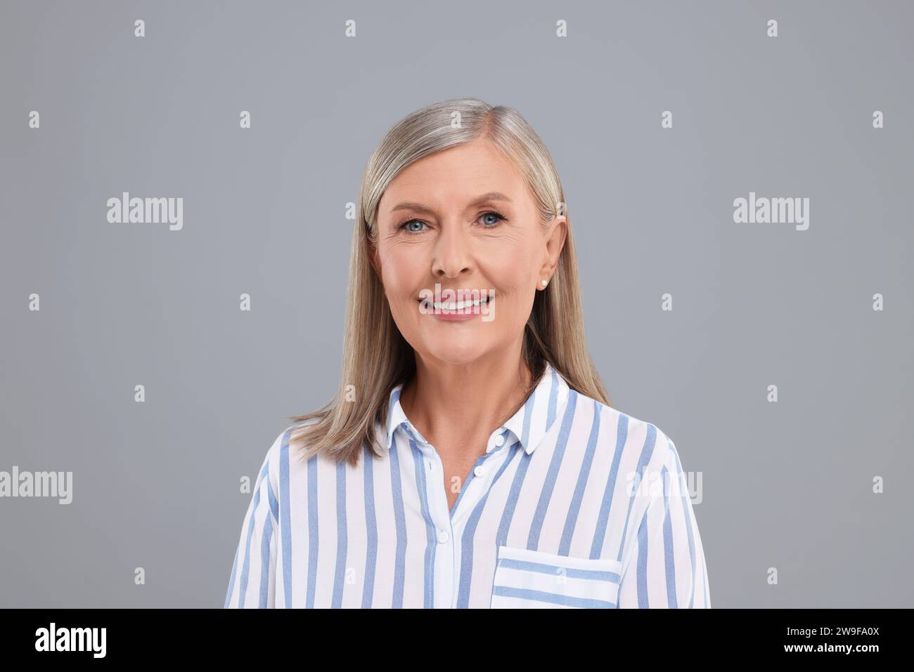 Portrait of beautiful middle aged woman on light grey background Stock ...
