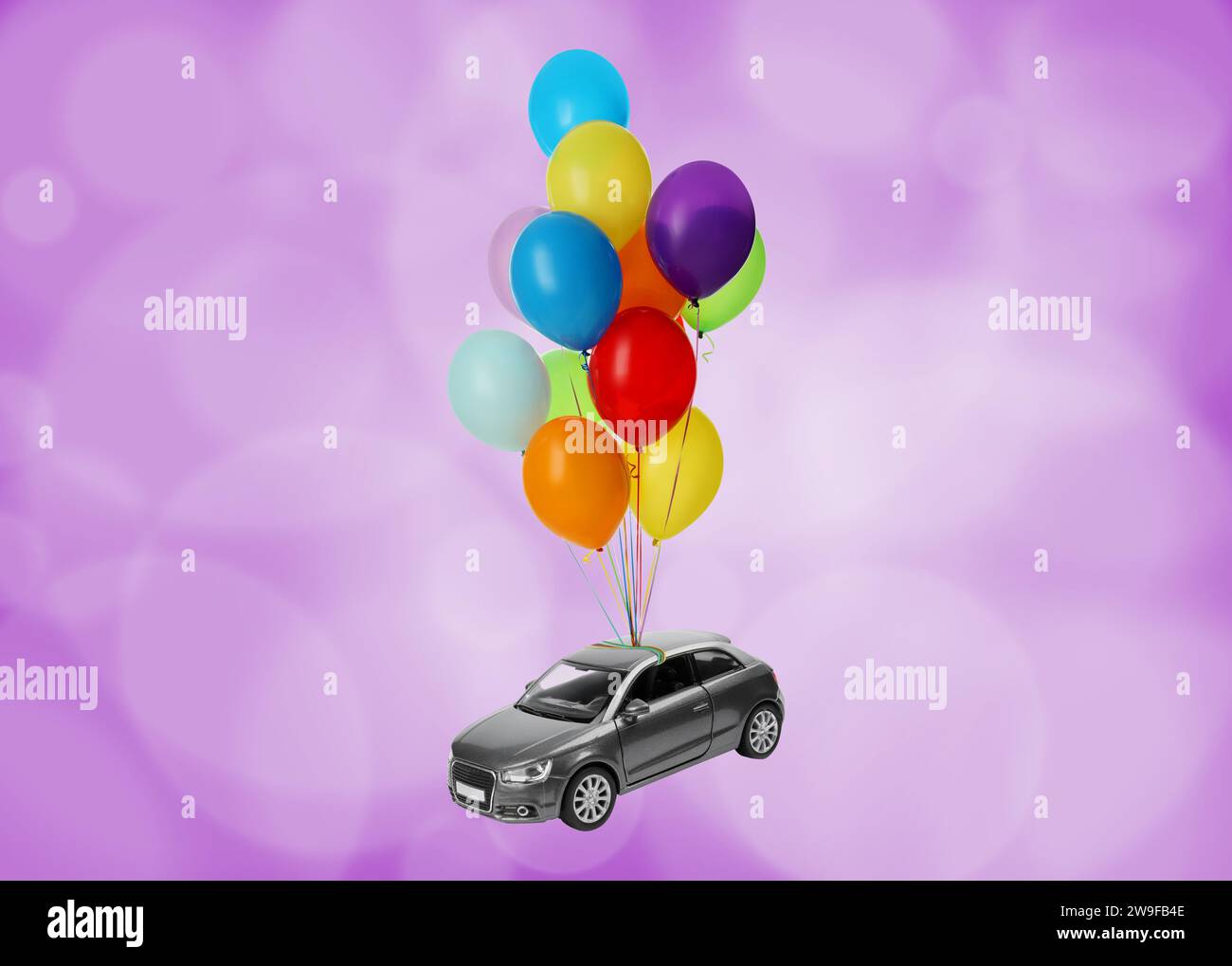 Many balloons tied to toy car flying on magenta background Stock Photo ...