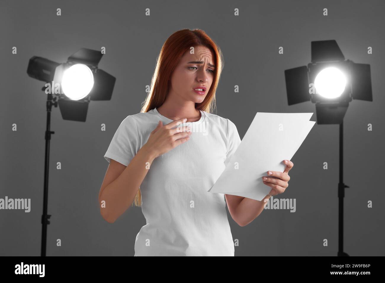 Casting call. Emotional woman with script performing on grey background ...