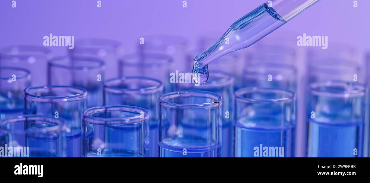 Laboratory analysis. Dripping reagent into test tube on violet ...