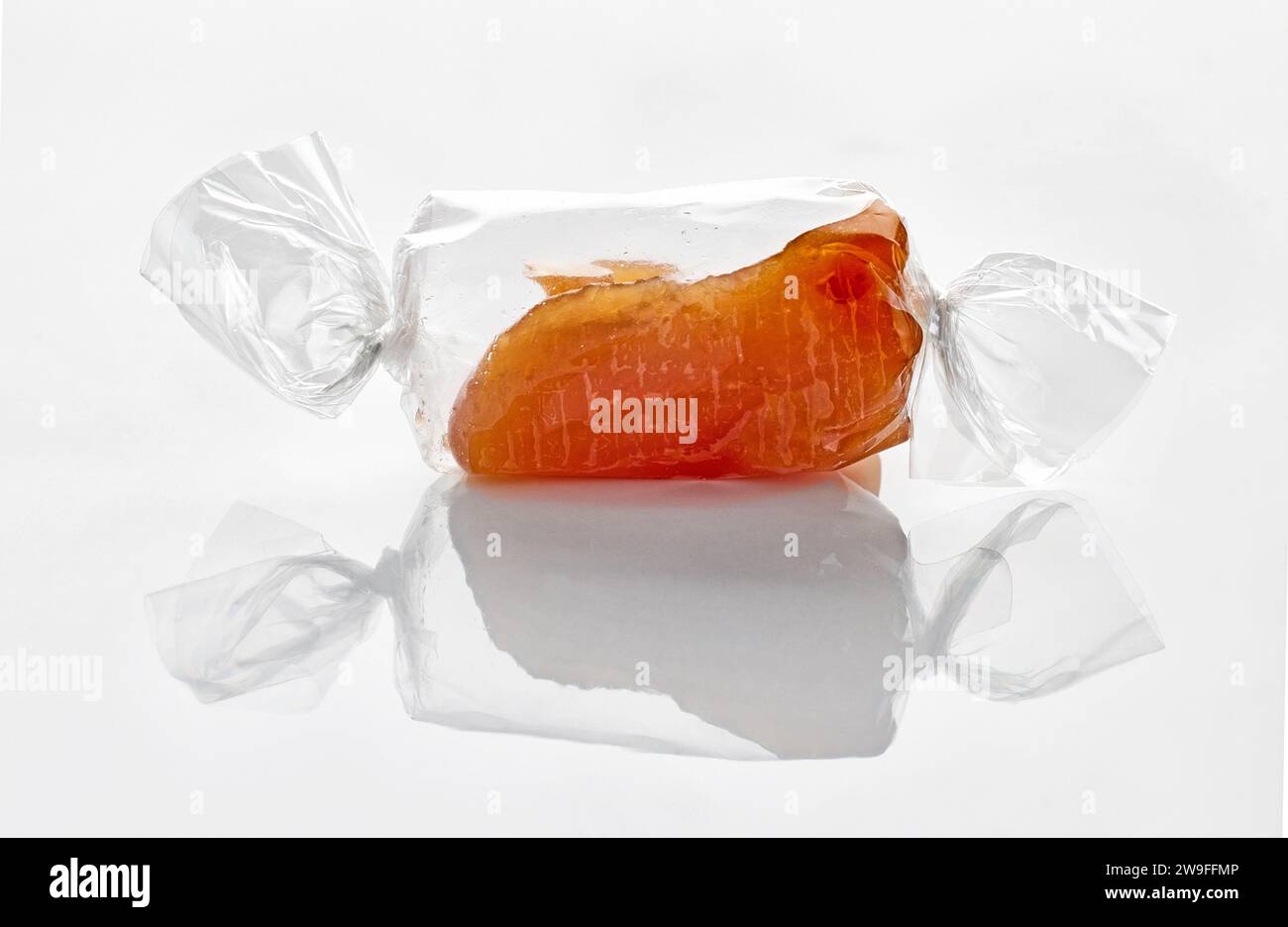 caramel candy in transparent wrapping paper on a white background Stock ...