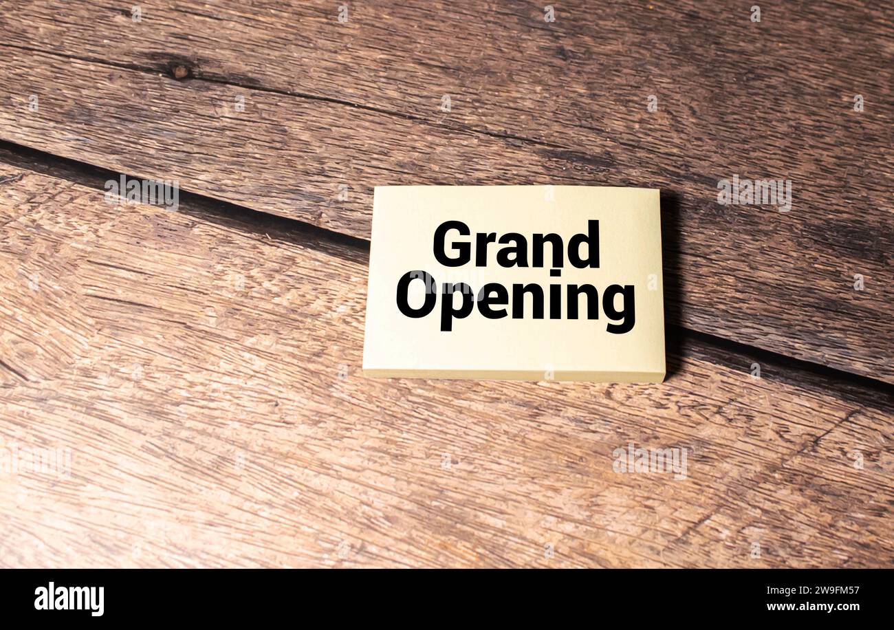 grand opening, text message on wood frame board on wood table ...