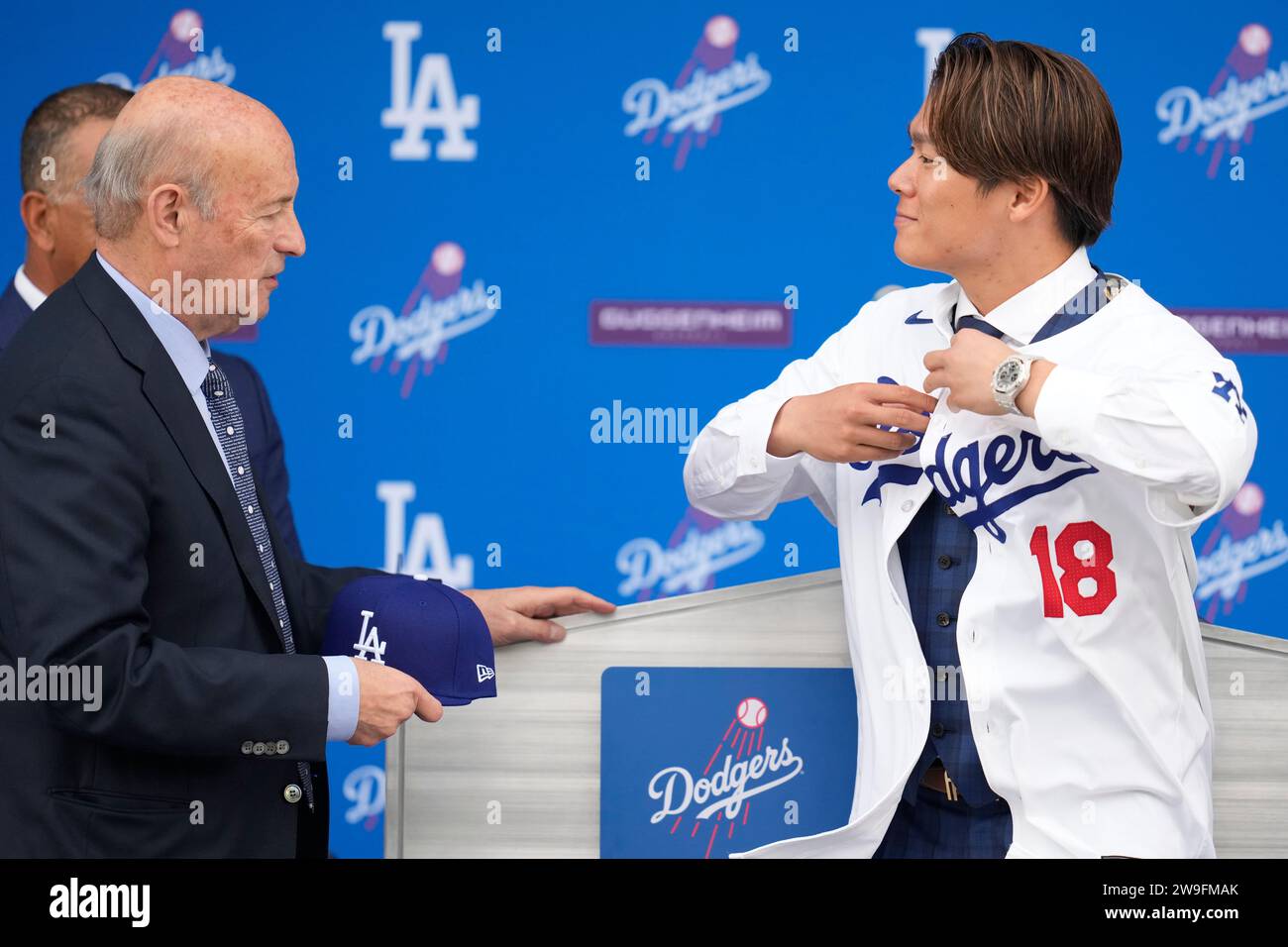 Yoshinobu Yamamoto, left, puts on a Dodgers jersey next to president ...