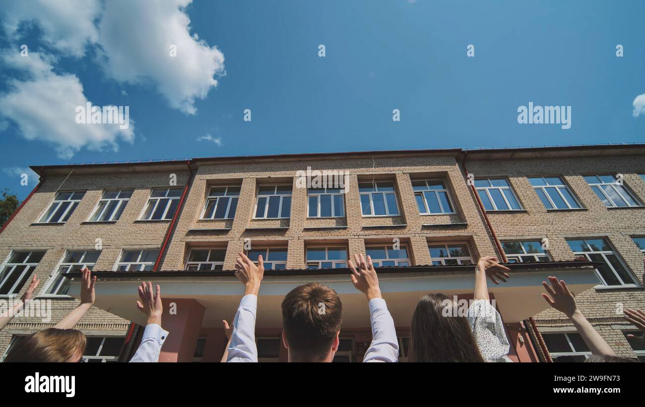 Graduates say goodbye to the school and wave goodbye Stock Photo - Alamy