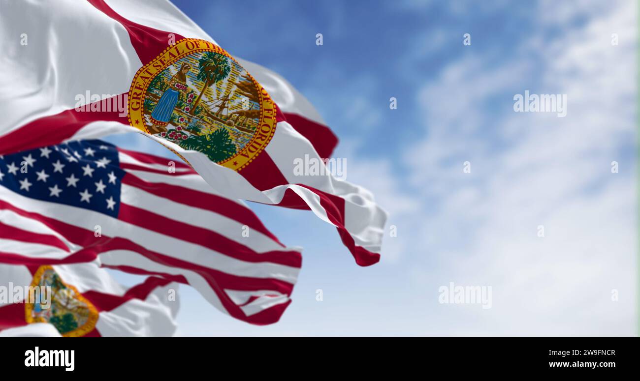 Flags of Florida and United States waving in the wind on a clear day ...