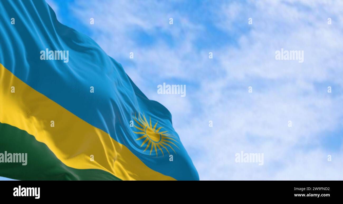 Close-up of Rwanda national flag waving on a clear day. 3 horizontal bands: blue, yellow, green ...