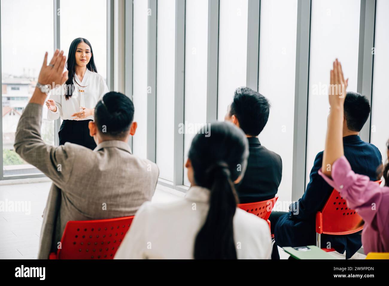 A large group in a seminar classroom actively engages in the discussion ...