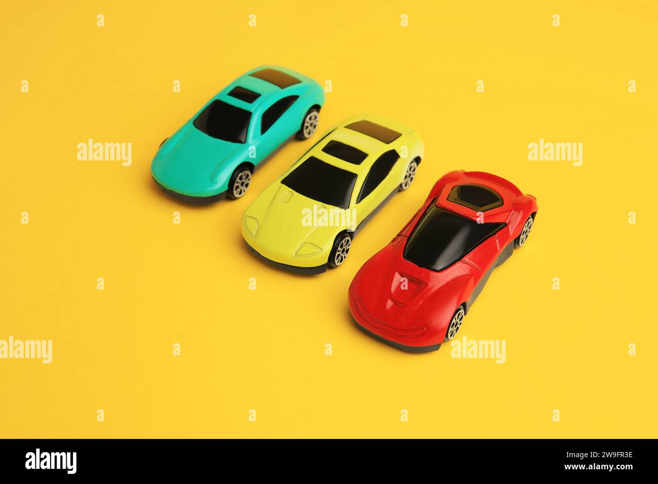 Different bright cars on yellow background. Children`s toys Stock Photo ...