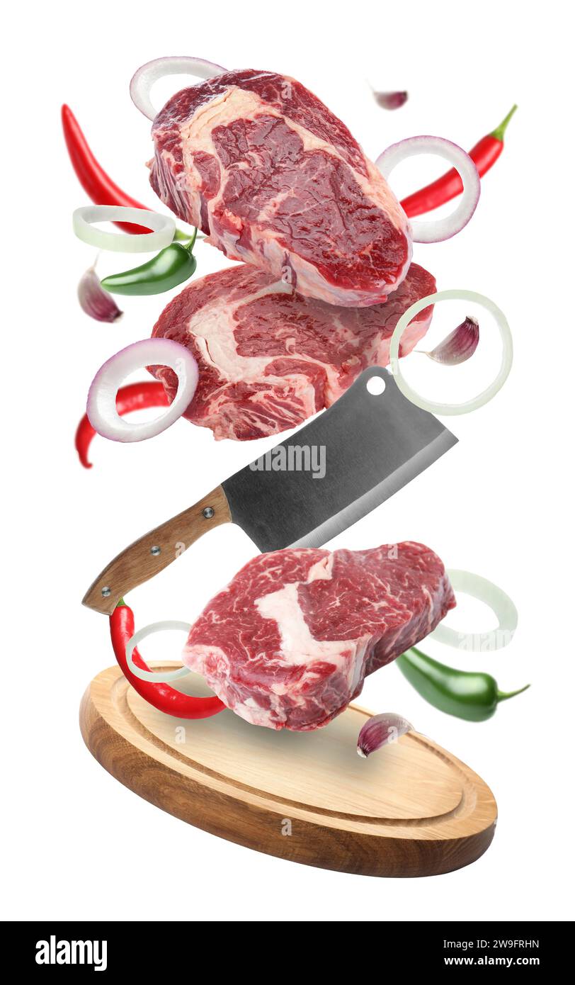 Beef meat, different spices, cleaver knife and board falling on white ...