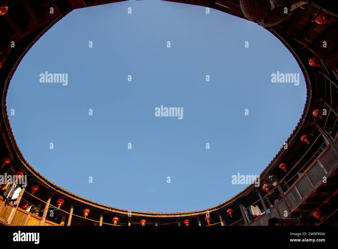 The sky above the round buildings of Hekeng Tulou Cluster in the early ...