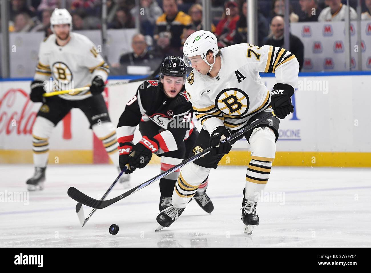 Boston Bruins defenseman Charlie McAvoy, right, skates the puck away ...