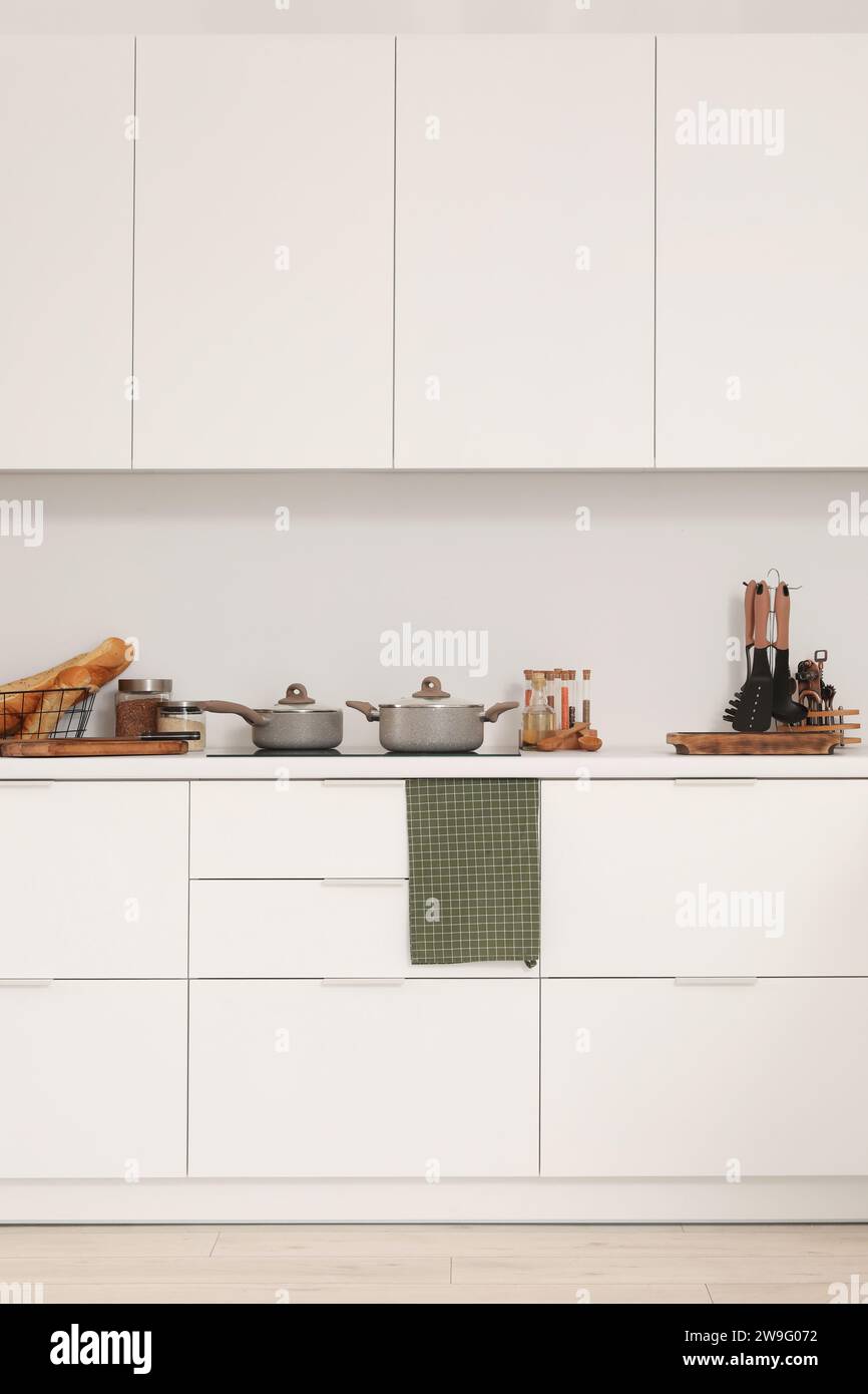 White kitchen counters with cutting boards, electric stove, cooking ...