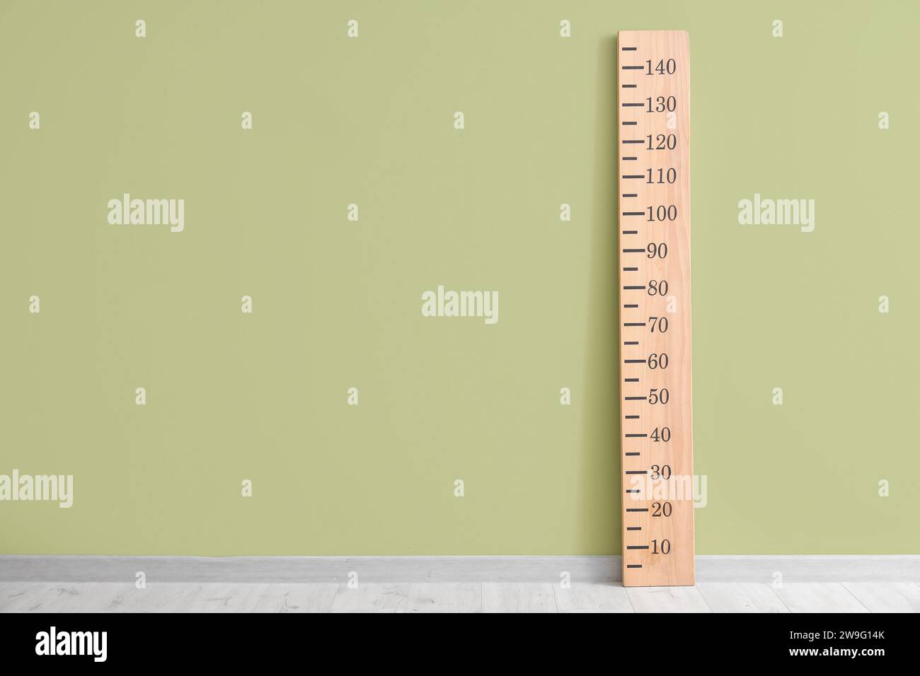 Wooden stadiometer near green wall Stock Photo - Alamy