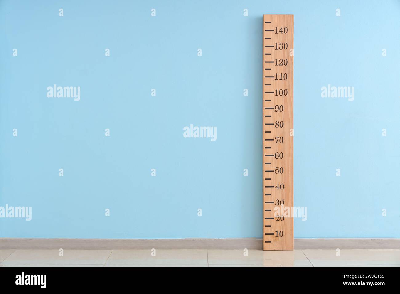 Wooden stadiometer near blue wall Stock Photo - Alamy