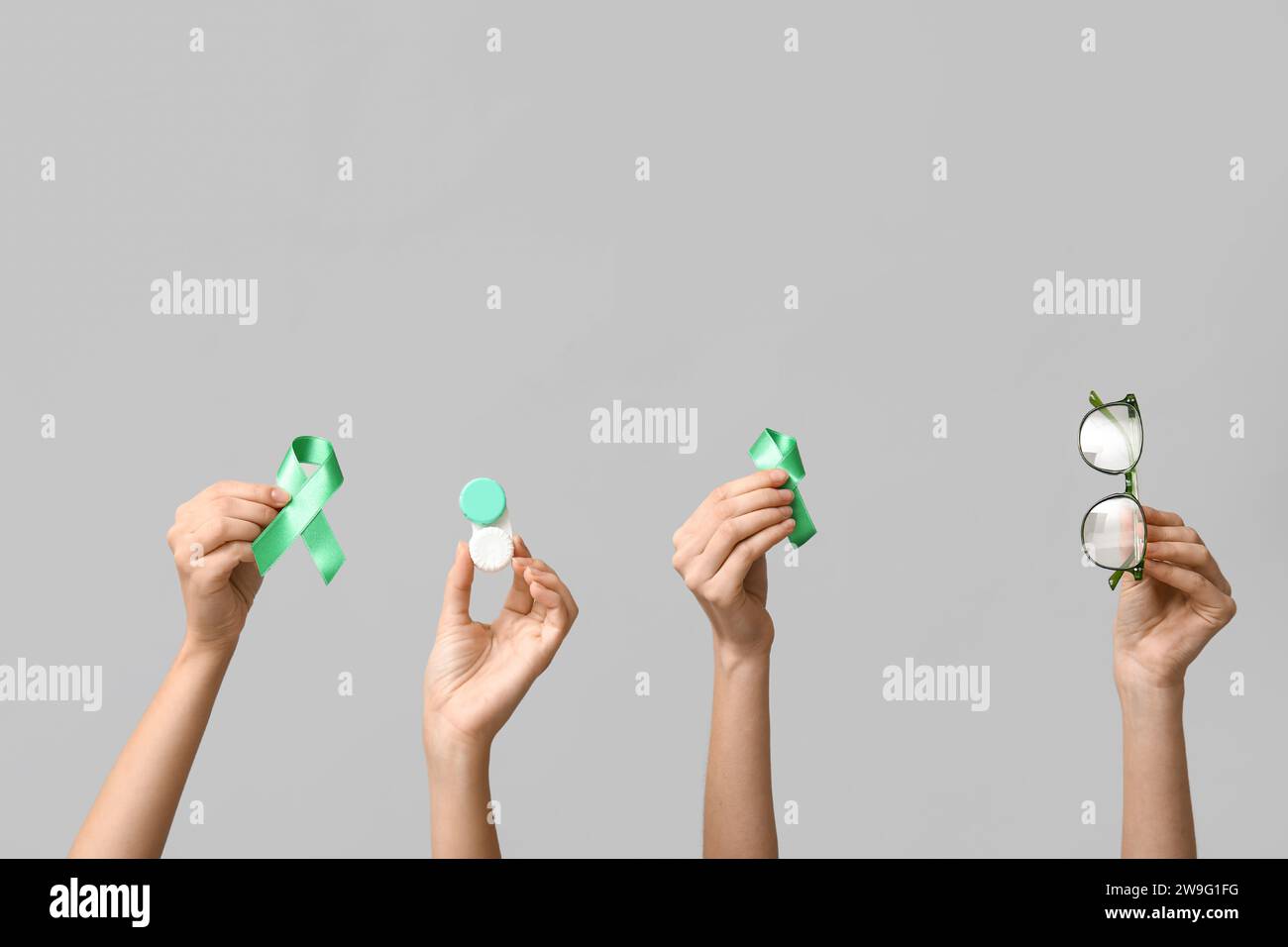 Female hands with container for contact lenses, green ribbons and ...