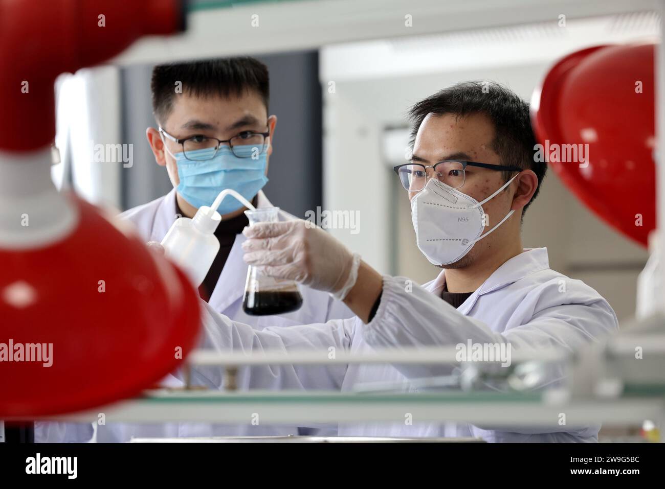 ZAOZHUANG, CHINA - DECEMBER 28, 2023 - Two postgraduate students work together to develop ...