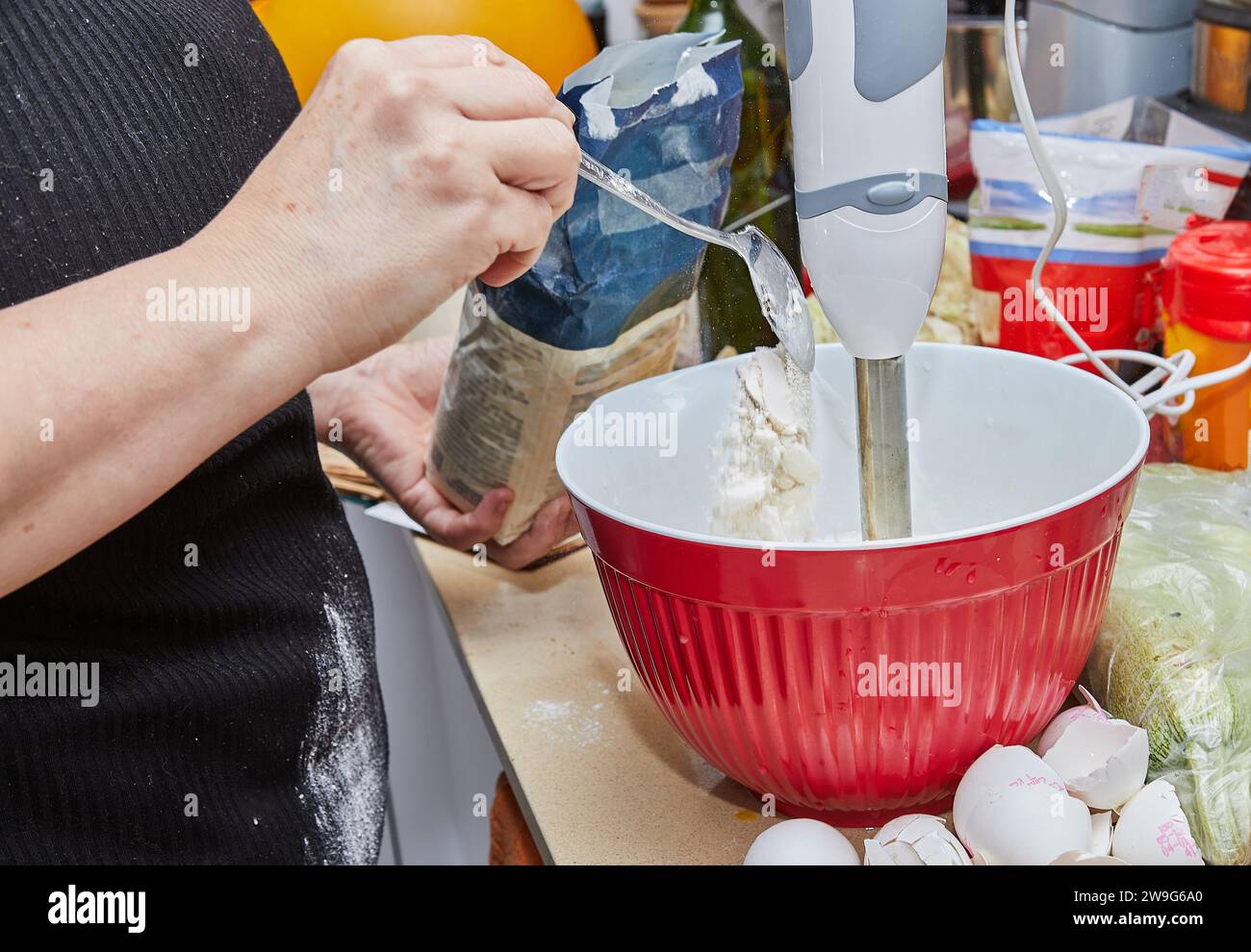 A busy homemaker is seen in her kitchen, skillfully whisking pancake ...