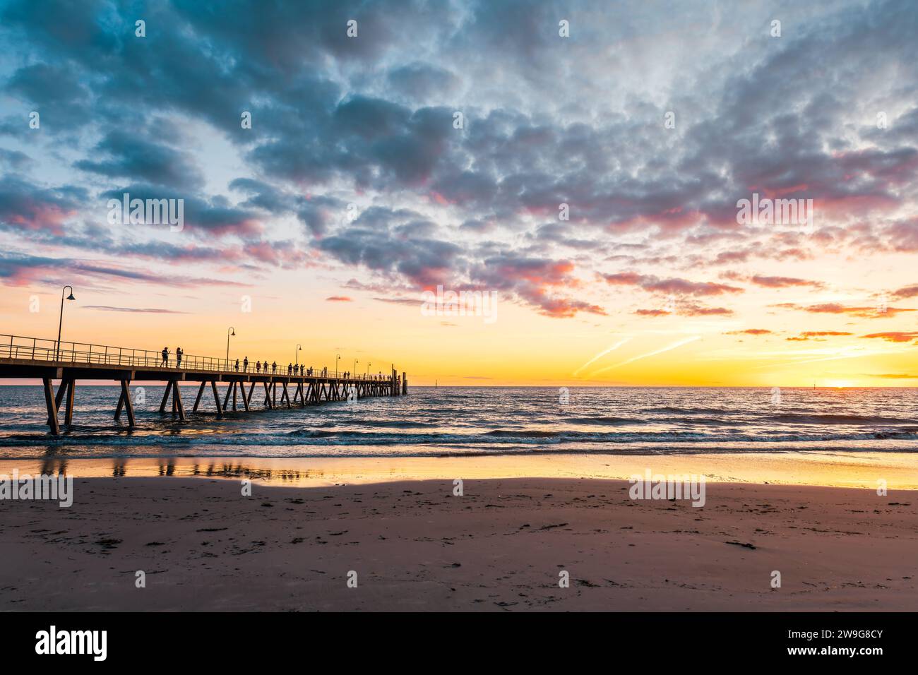 Glenelg Beach jetty silhouette with people walking along at sunset ...