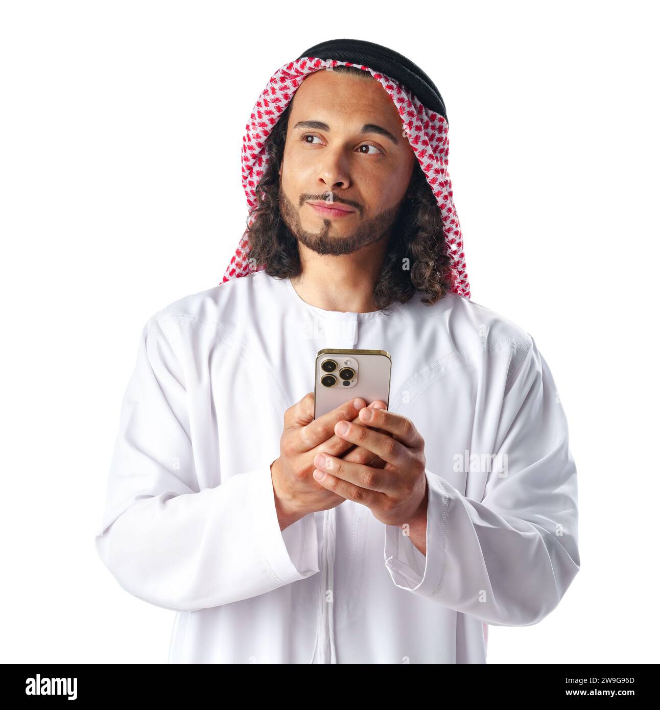 Young Arab man in traditional dress thobe using smartphone at white ...