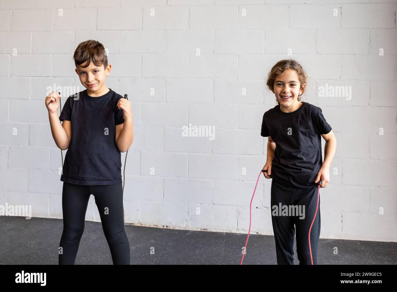 Horizontal photo elementary boy and girl, dressed in black sportswear ...