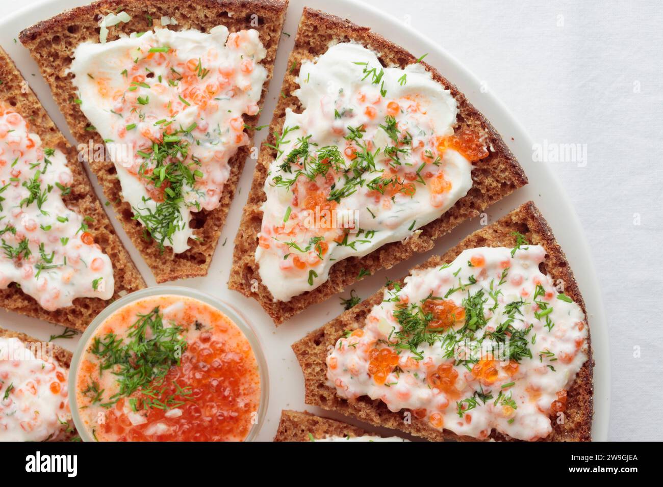 Homemade appetizer with red caviar, sour cream, dill, onion and rye ...