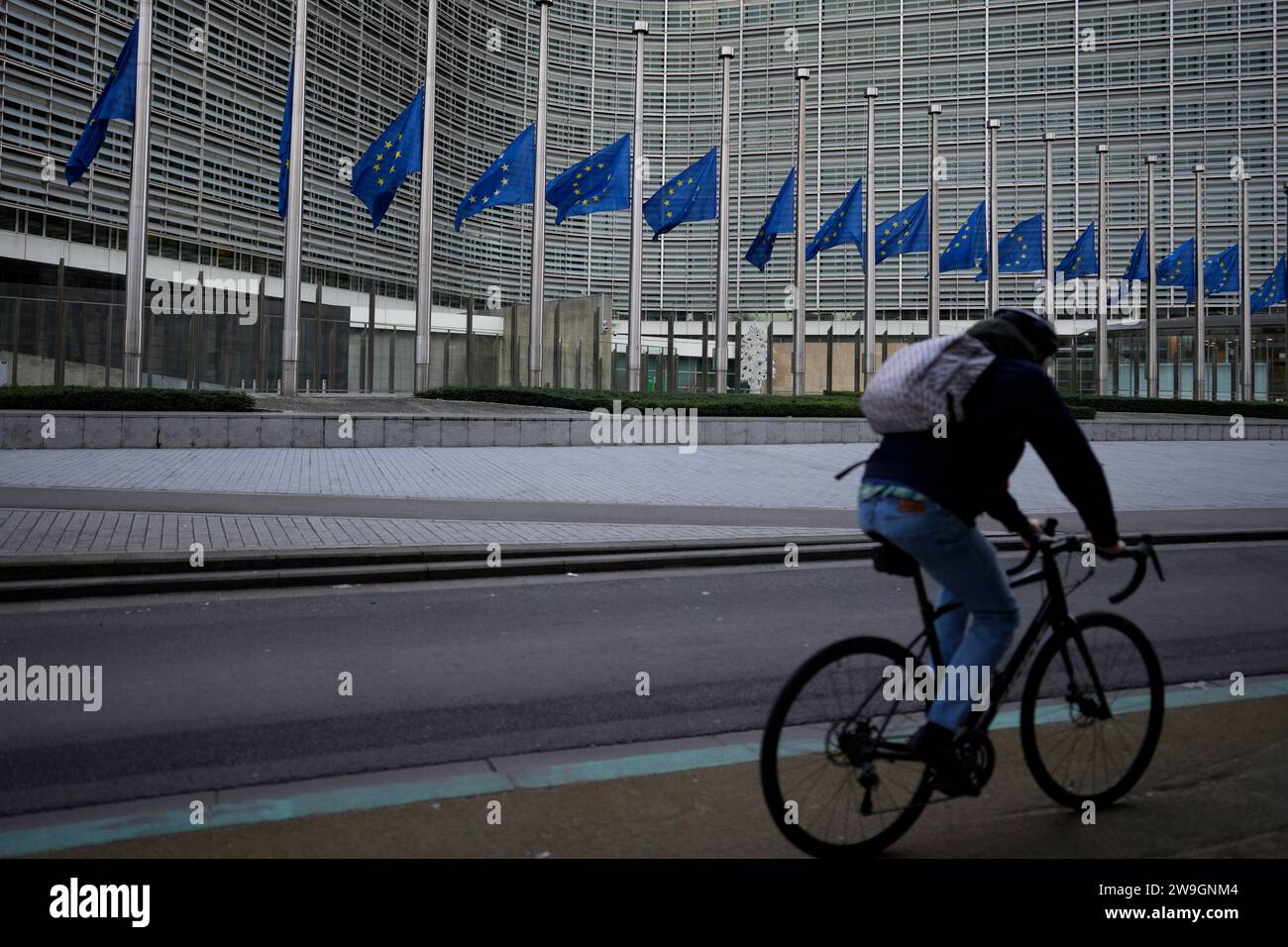A cyclist goes past as European Union flags flap in the wind at half ...