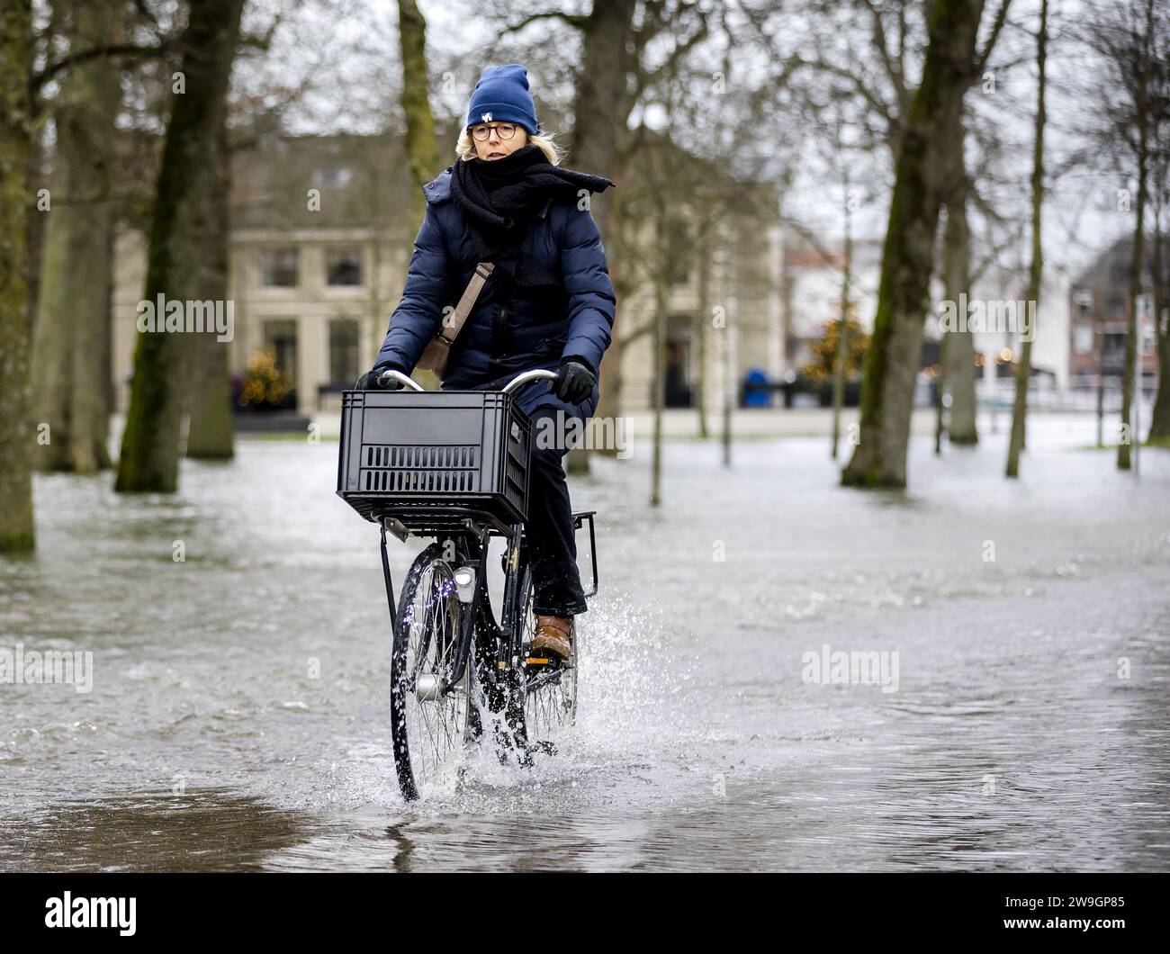 DEVENTER - A woman cycles through a flooded street in Deventer. The ...