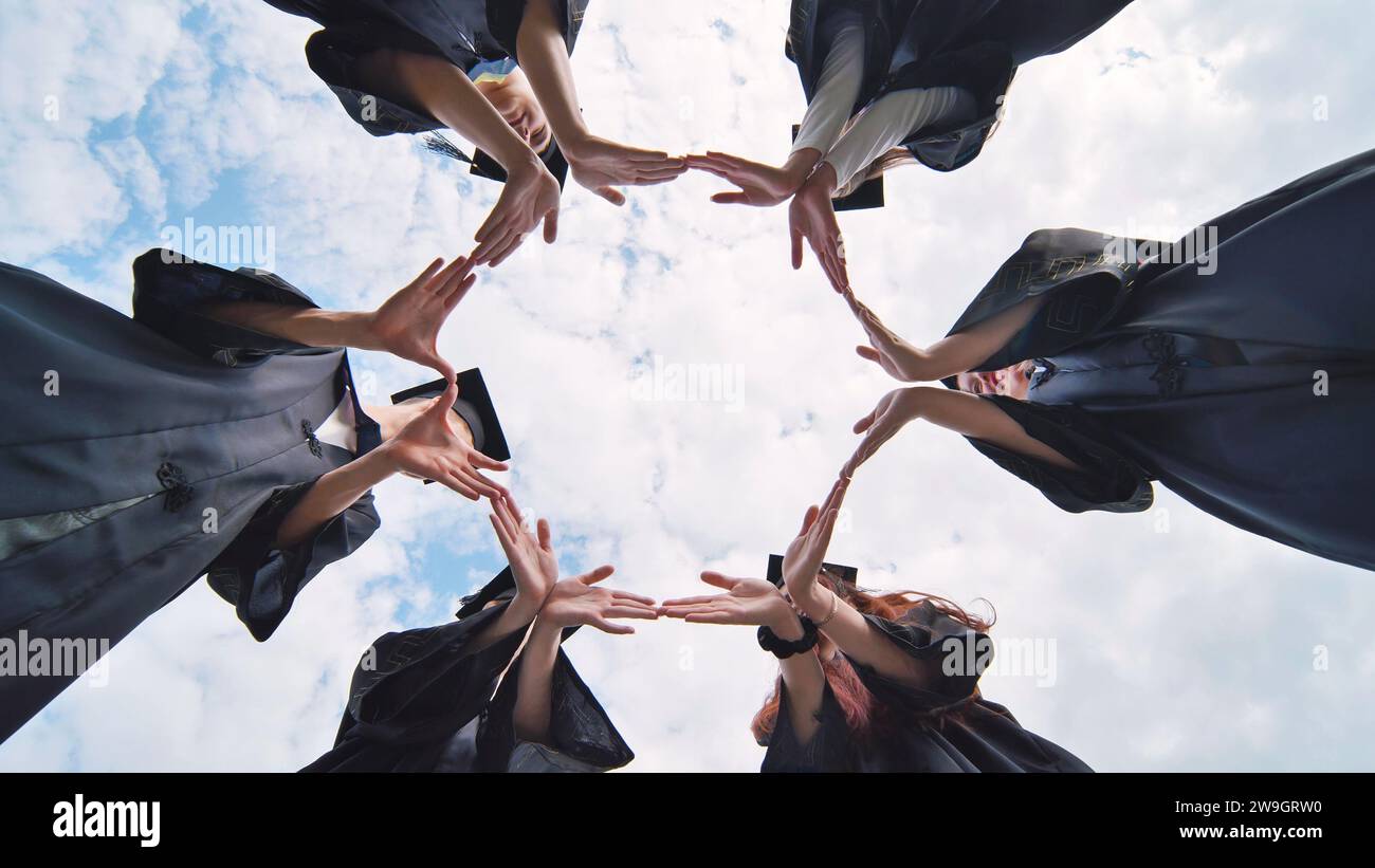 College graduates make a circle of their hands Stock Photo - Alamy