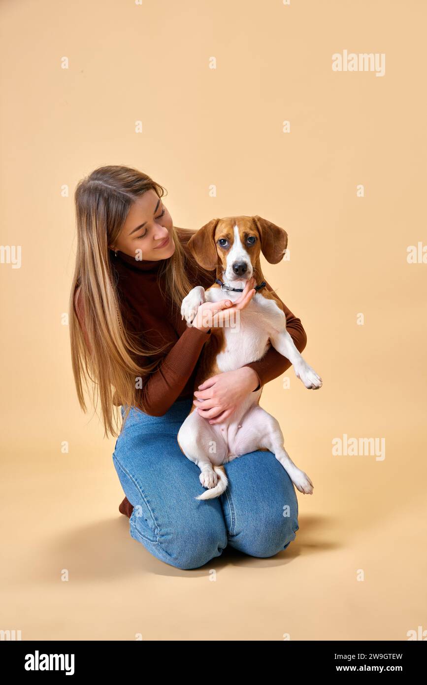 Lady sitting with dog, purebred Beagle. Beautiful woman holding in her ...