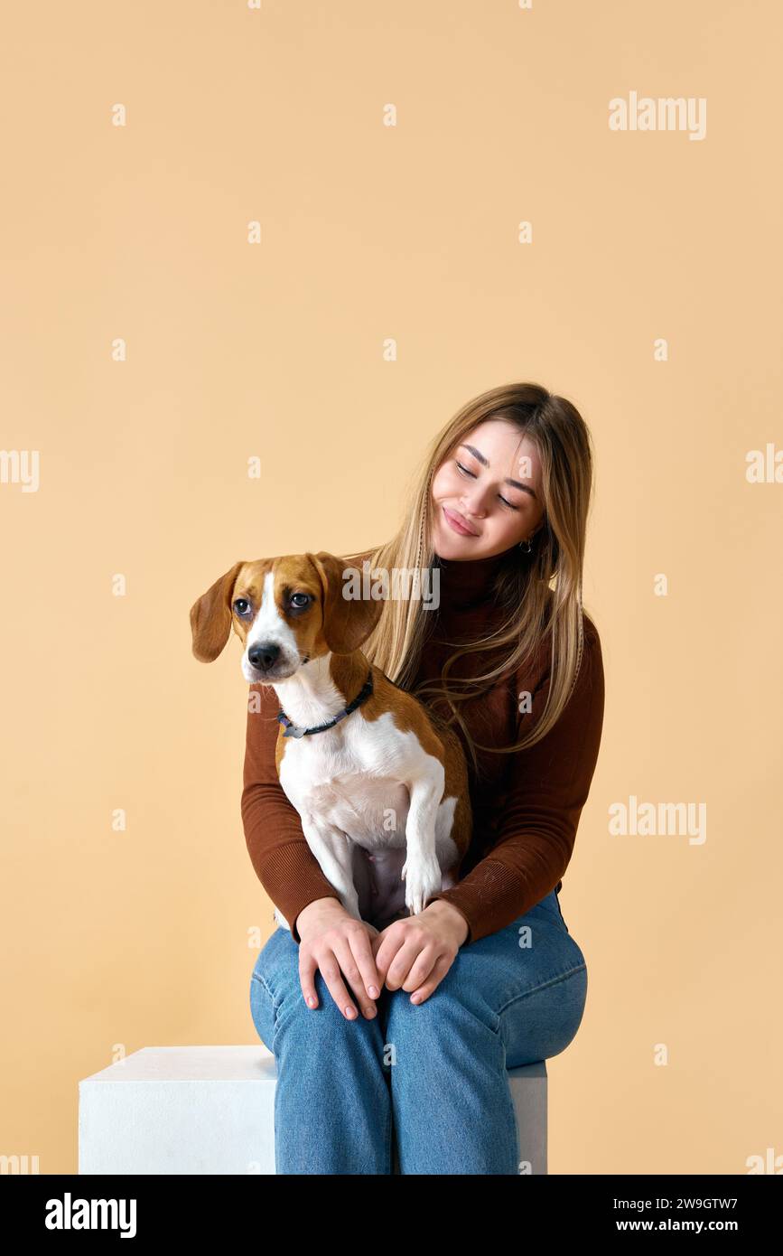 Portrait of cute Beagle on hands of attractive happy smiling young ...
