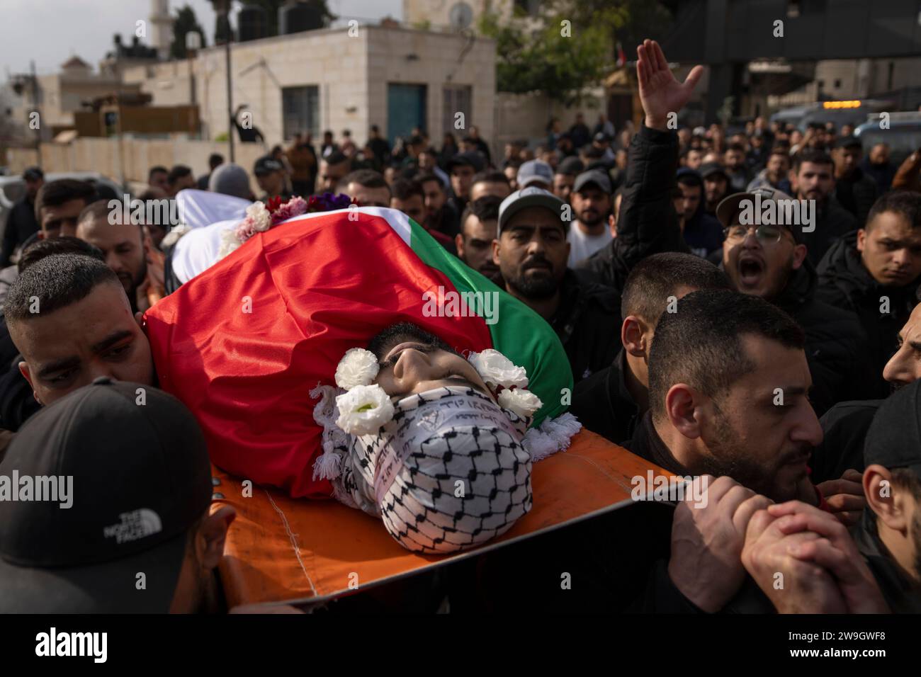 Palestinian mourners carry the body of Hazem Qatawi, 23, headband reads ...