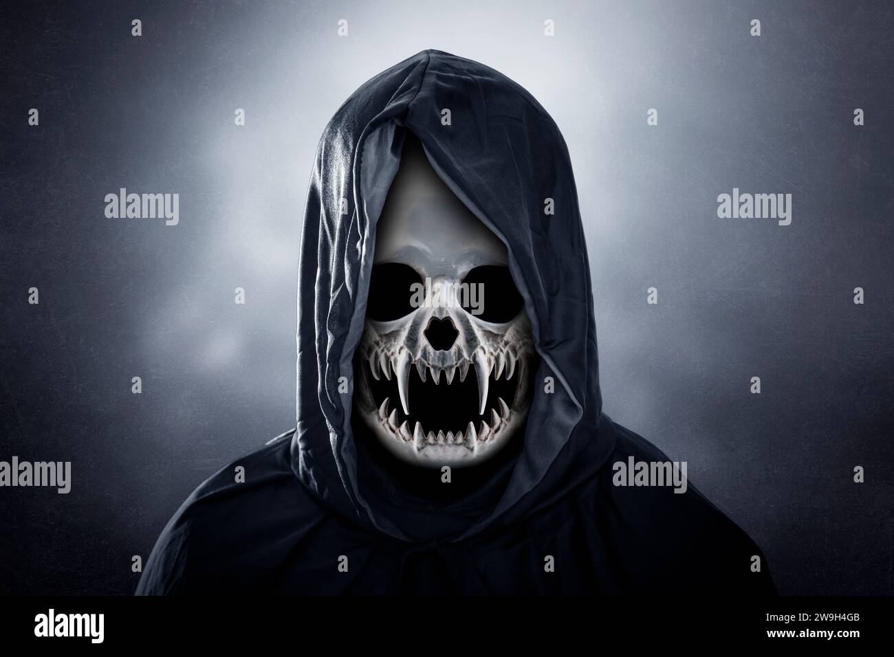 Grim reaper in hooded cloak over dark misty background at night Stock ...