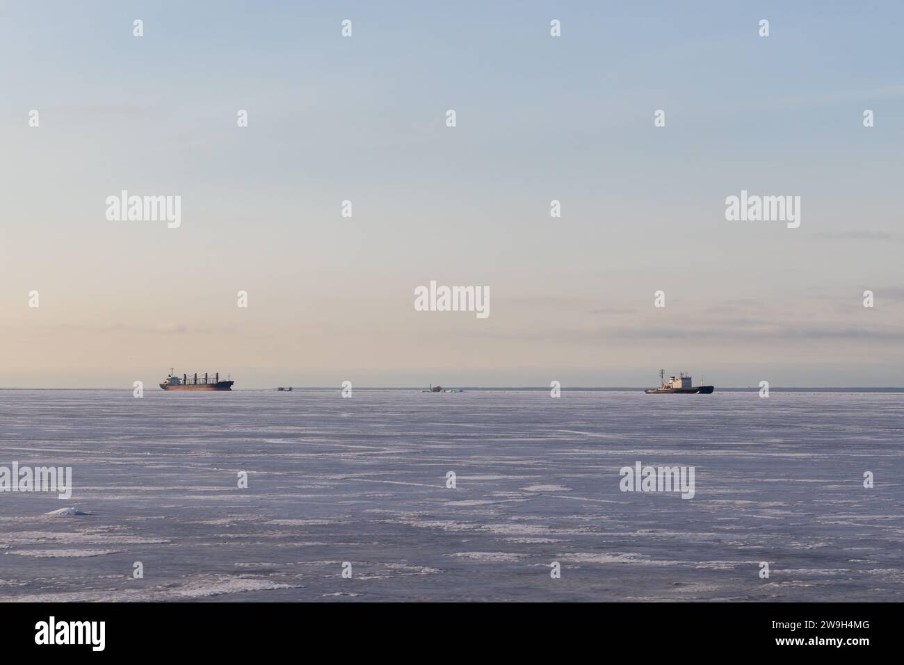 Icebreaker and cargo ship sail the channel to the port of Saint ...
