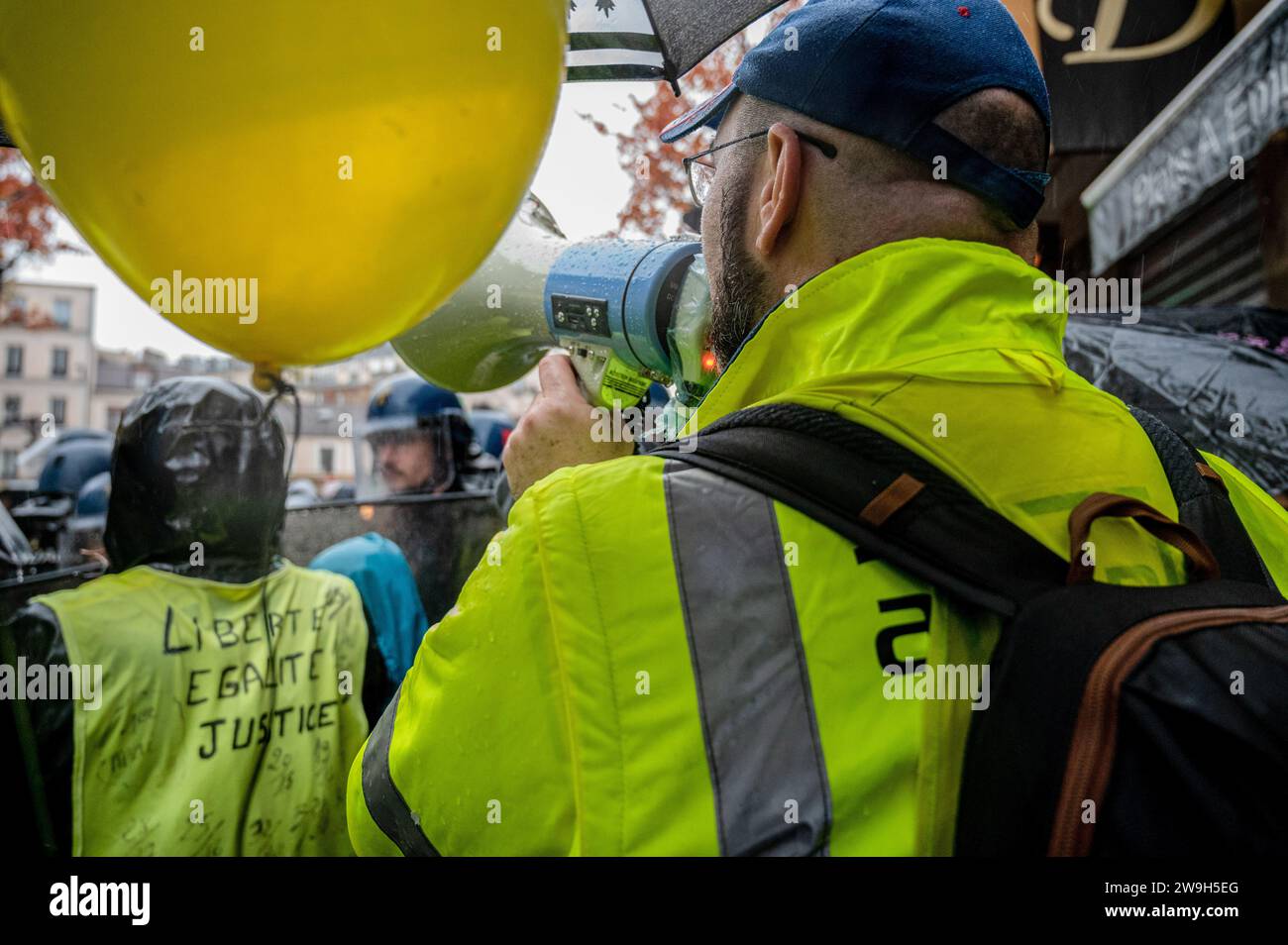 A "yellow vest" anti-government protester chants slogans through a ...