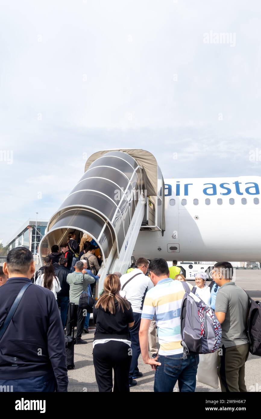 Passengers boarding airplane operated by Air Astana in Astana airport ...