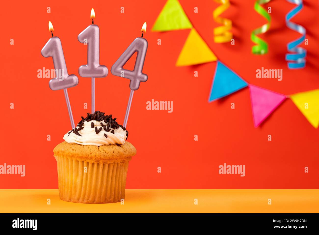 Birthday cake with number 114 candle - Sparkling orange background with ...