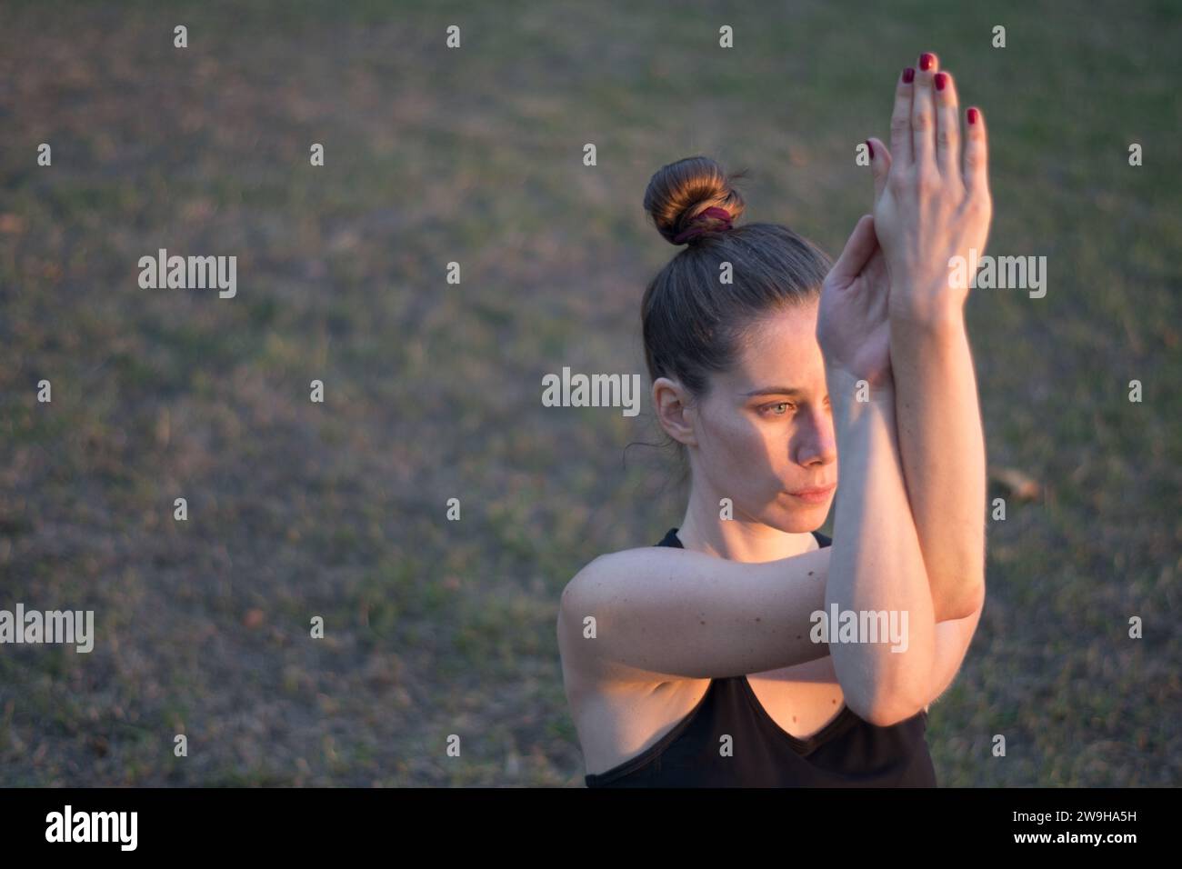 A young White woman in yoga eagle arms stance Stock Photo - Alamy