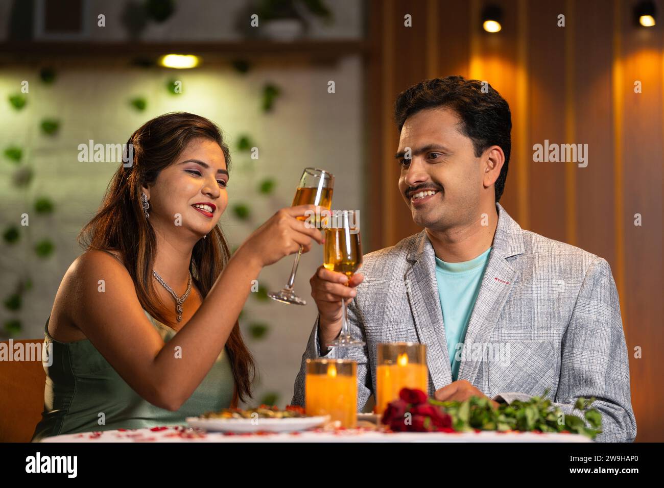 Indian Romantic couples champagnes wine glasses during candlelight ...