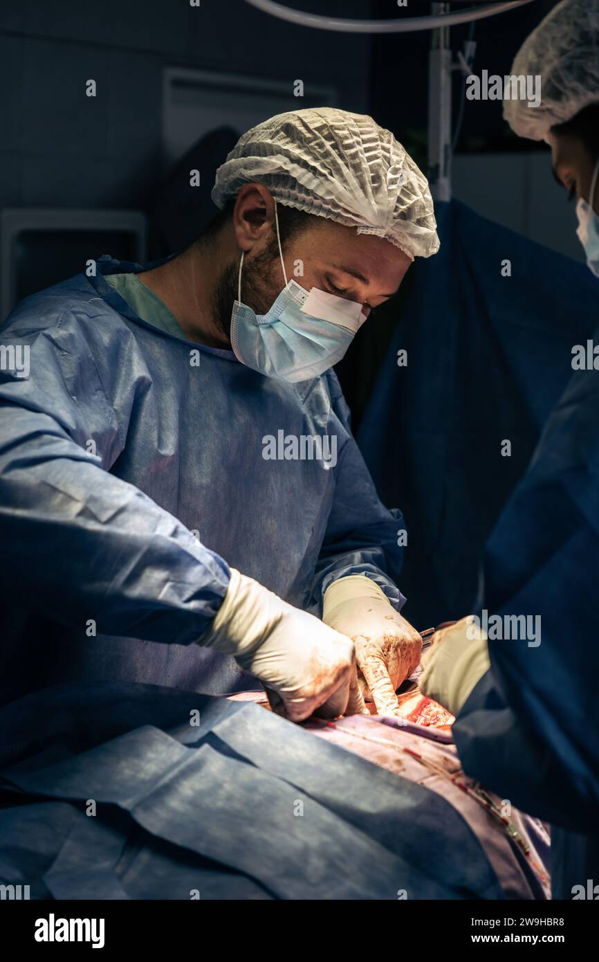 A team of doctors performing spine surgery on a patient with scoliosis ...