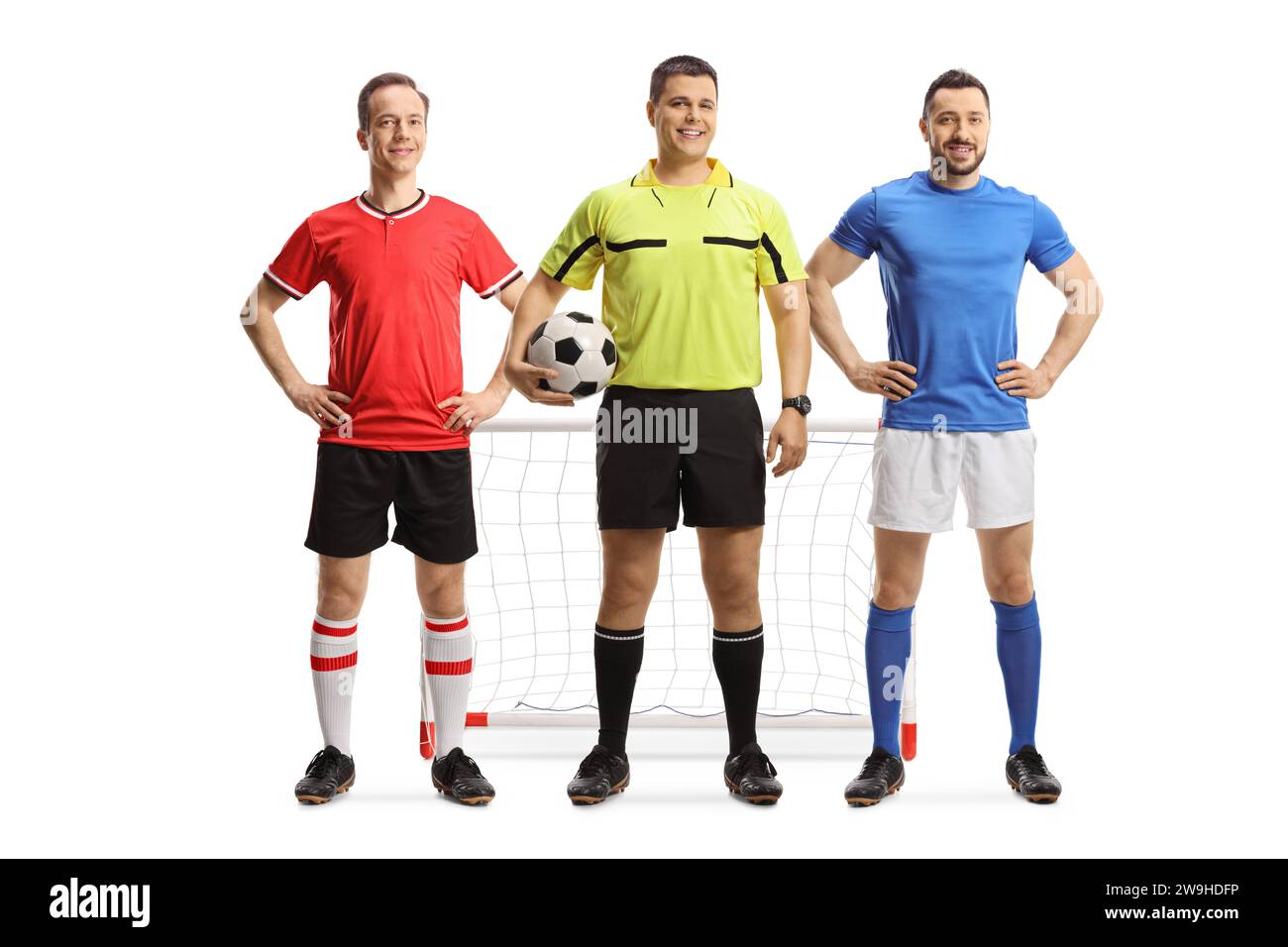Football players and a referee holding a ball in front of a goal ...