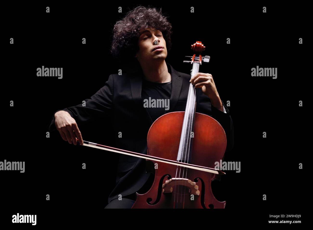 Young male artist playing a cello isolated on black background Stock ...