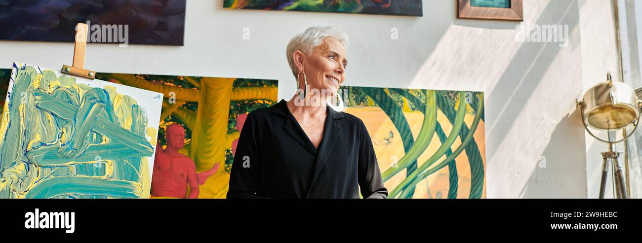 trendy mature female artist smiling and looking away near colorful ...