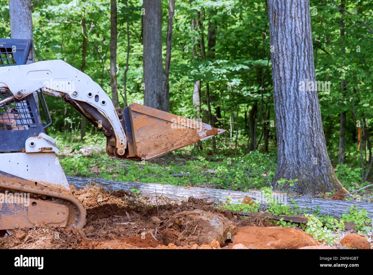 Mini bulldozer is being used to work with earth to move soil in order ...