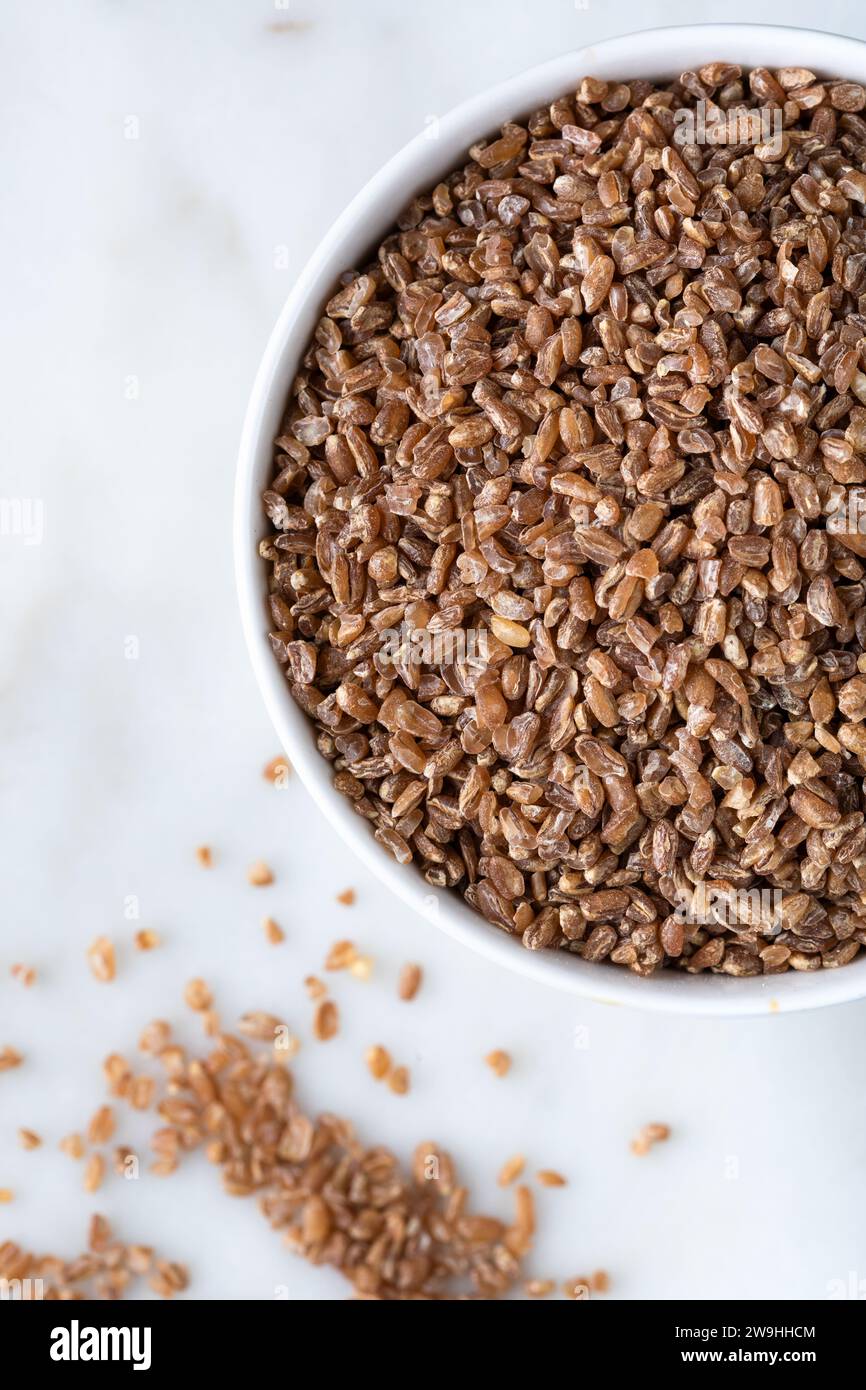 Close up of wheat grains in bowl on marble background. Healthy food ...