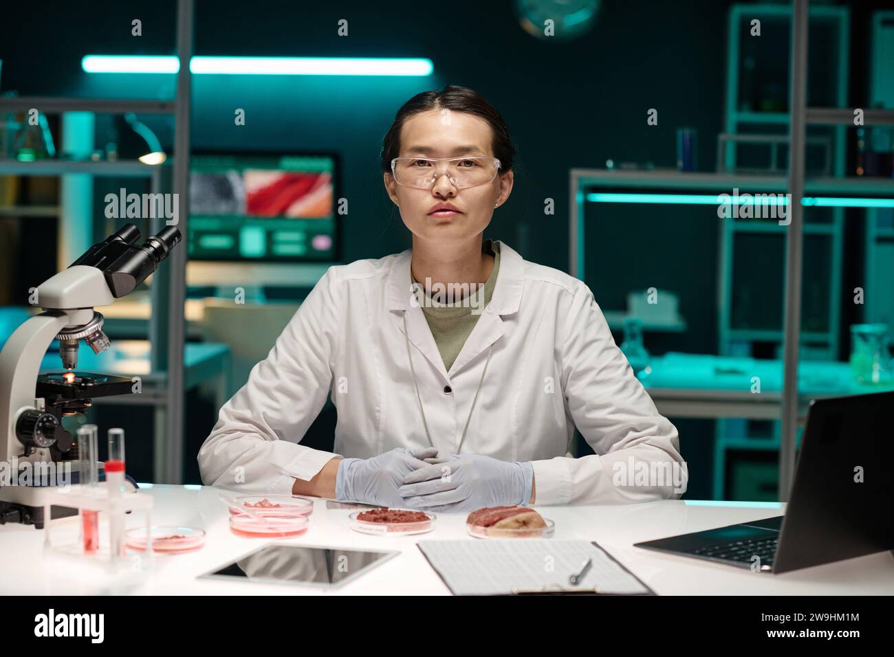Portrait young scientist sitting desk hi-res stock photography and images - Alamy
