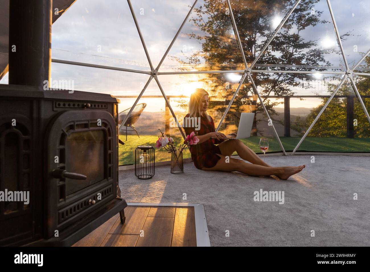 Woman working on laptop geo dome tents. Green, blue background. Cozy, camping, glamping, holiday ...