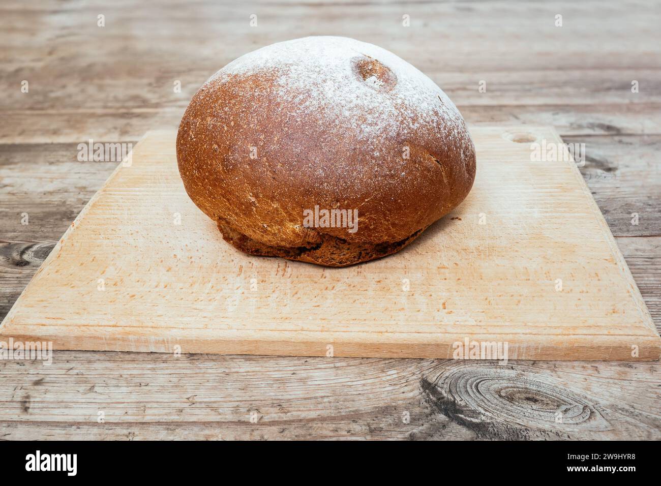 A loaf of freshly baked wheat-rye bread with white topping and a crispy ...