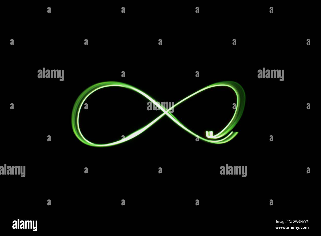 A photograph of an infinity loop symbol in vibrant green light in a ...