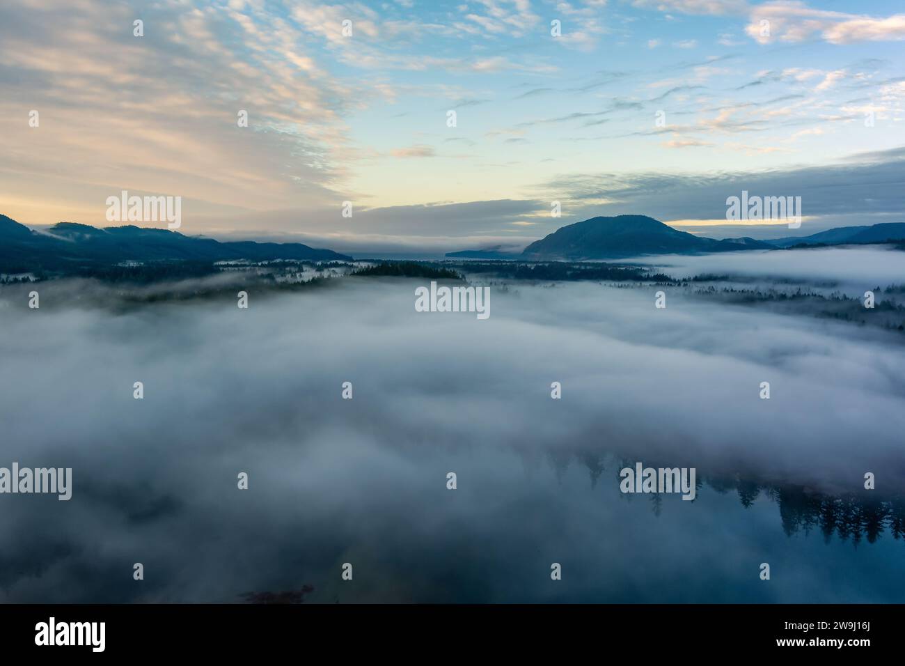 Valley by Lake, Mountains and Green Trees covered in fog. Canadian ...