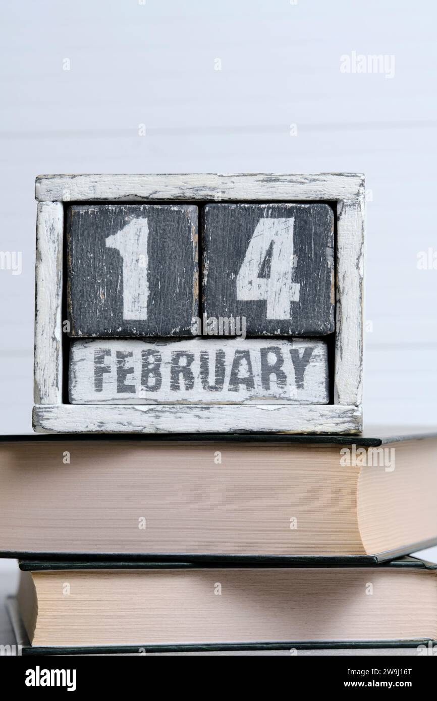 February 14th on the calendar and books on white background ...